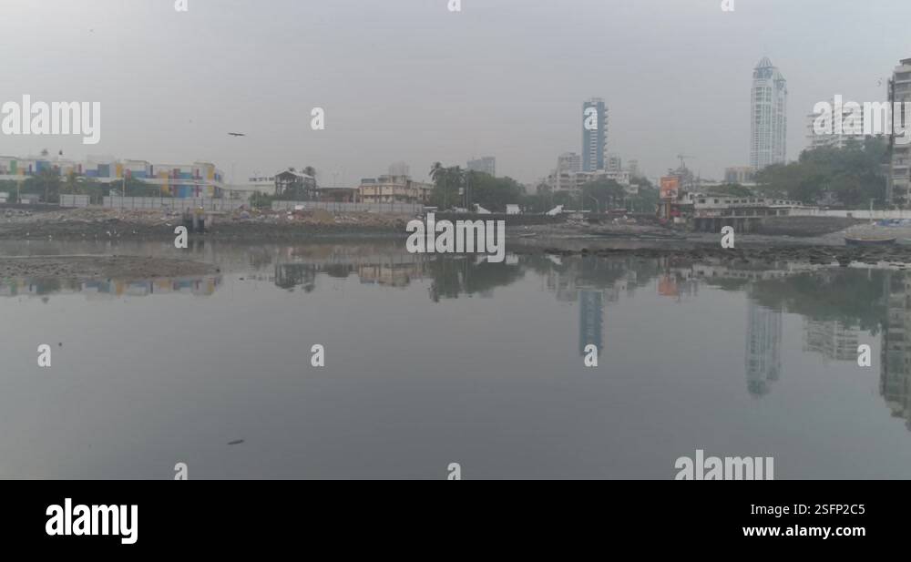 Flying low over a polluted seawater section of Haji Ali with crows ...