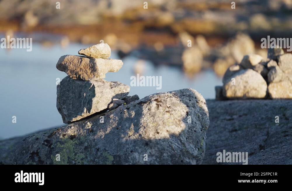 A close-up shot of the small stone cairns on the top of the big boulder ...