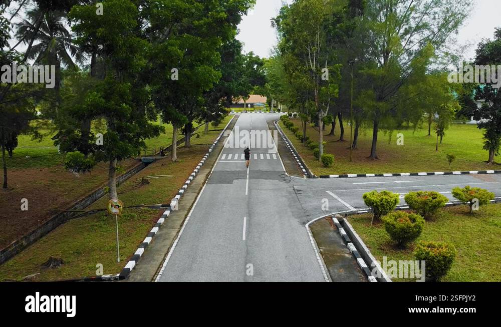 A man exercising and running in the middle of the road captured from ...