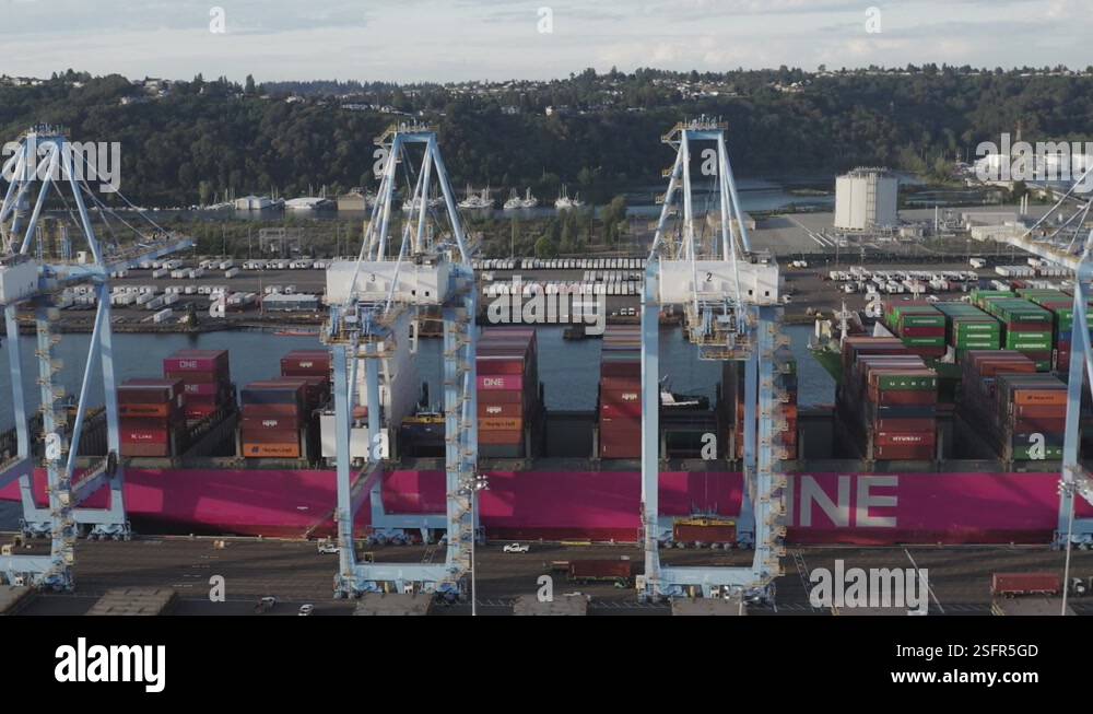 Big Cranes Loading Storage Containers Into Ship - aerial panning shot ...