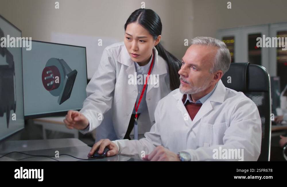 Diverse engineers in lab coats discuss design of 3d model on computer ...