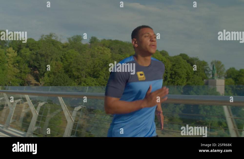 Portrait of muscular build sporty African man running in city at ...
