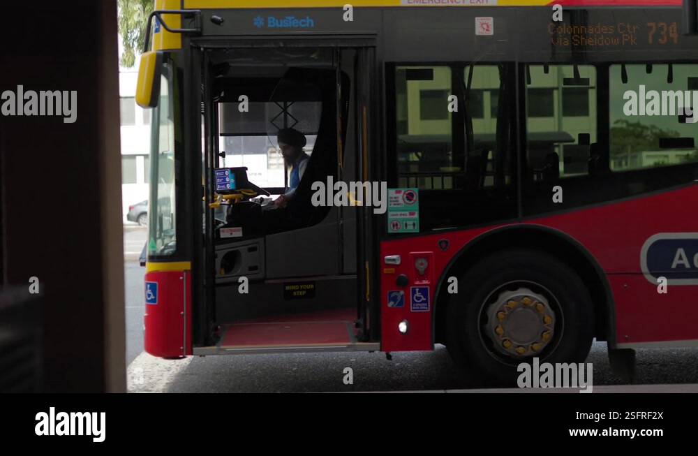A busy bus interchange and bus stop with passengers boarding and ...