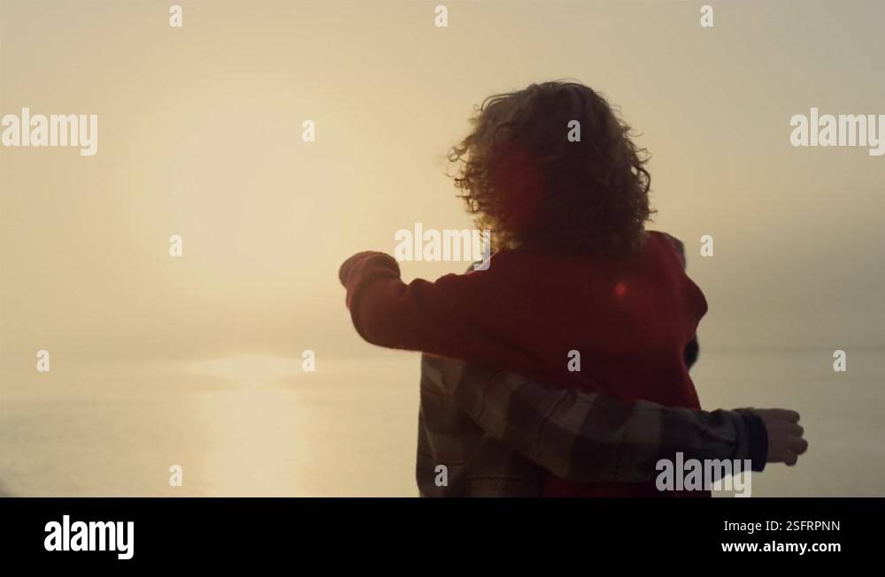 Woman and man dancing on beach at sunrise. Romantic couple hugging at ...