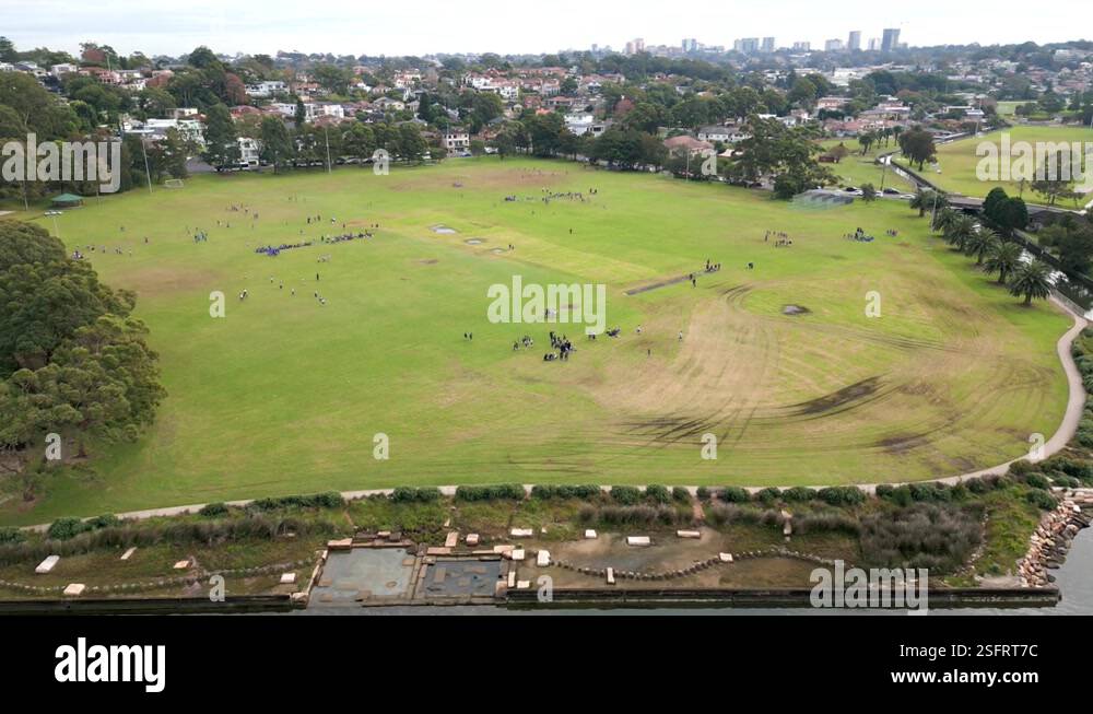 Aerial view of park or playground green field full of school kids and ...