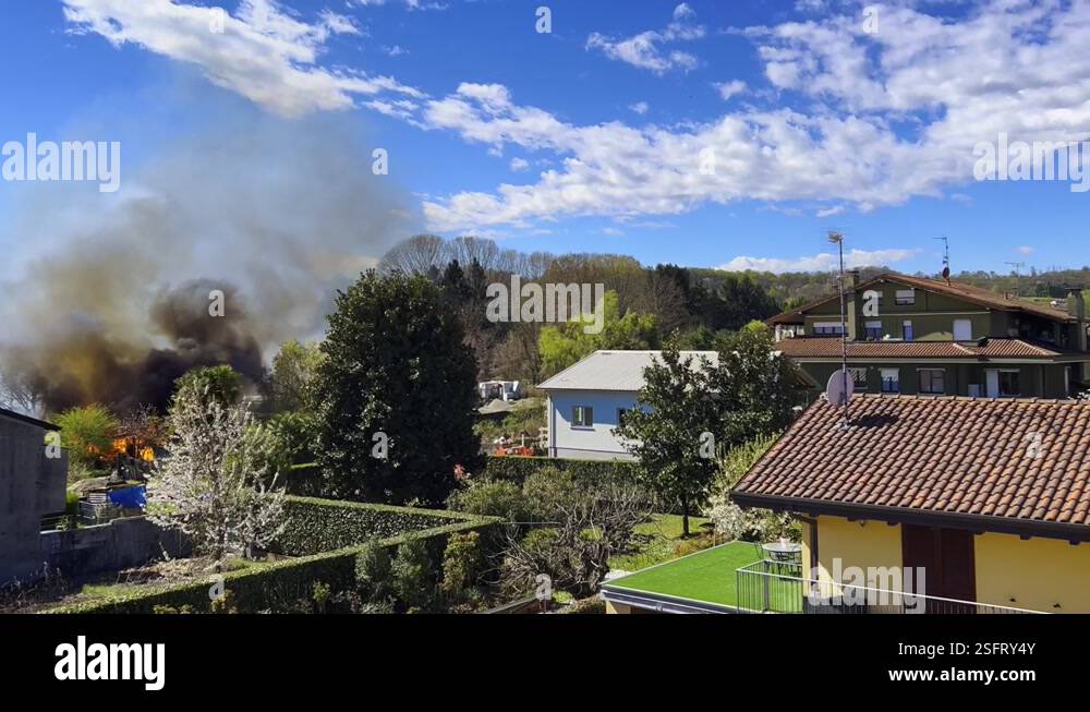 House on fire with flames and black smoke rising in the sky. Zoom out ...