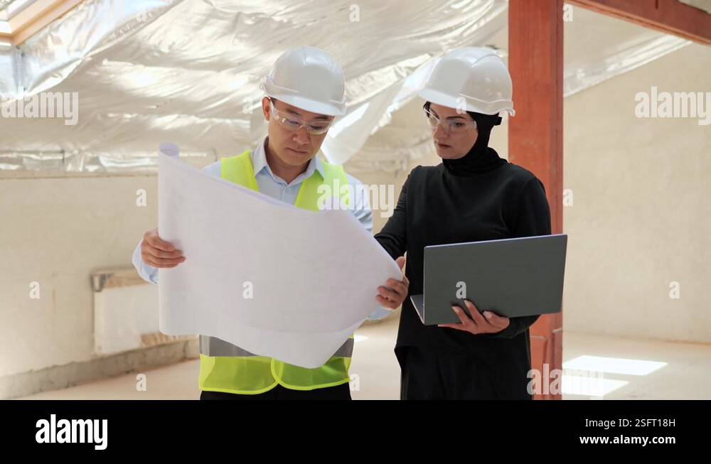 Muslim female investor wearing a hijab talking to Asian engineer Stock ...
