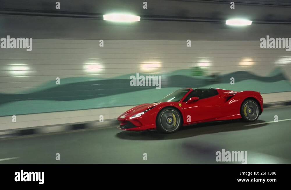 Rolling shot of Red Ferrari F8 Tributo supercar driving at night in ...