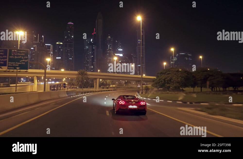 Rolling shot of Red Ferrari F8 Tributo supercar driving at night in ...