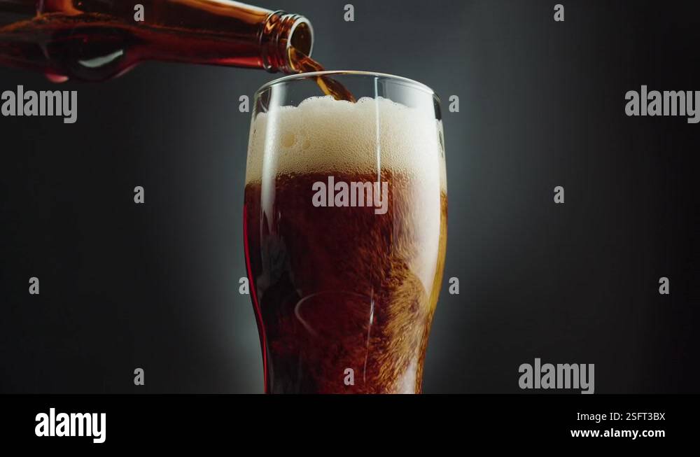 Foamy beer in glass close-up. Pouring alcohol stout beer drink in mug ...