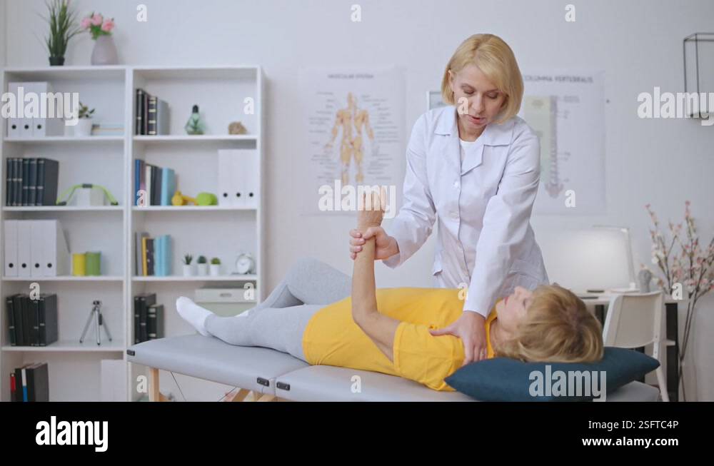 Rehabilitation doctor helping training patient's muscles, recovery ...