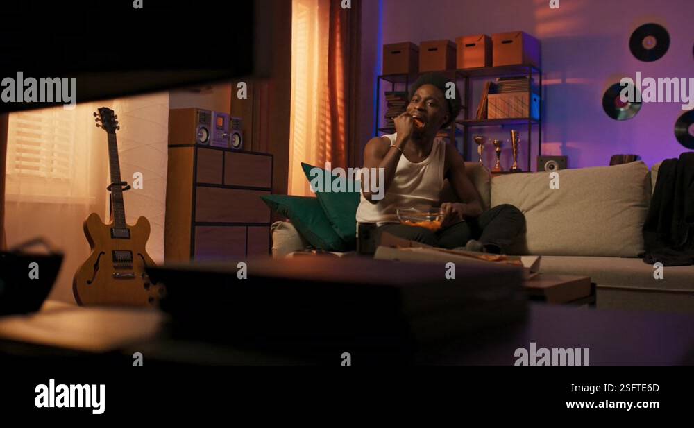 A laid-back guy relaxes on the couch in the living room, a man with an ...