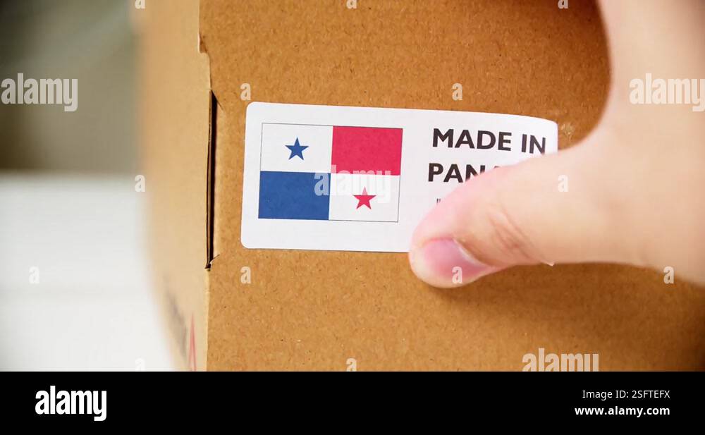 Hands applying MADE IN PANAMA flag label on a shipping cardboard box ...
