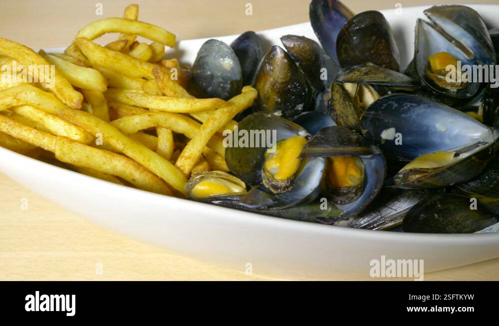 Moules frites cooked mussels in shells with fries in a bowl, ready to ...