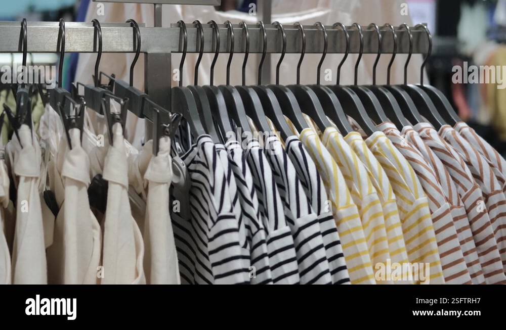 Clothes of various sizes hang on a hanger in the store, hung by color ...