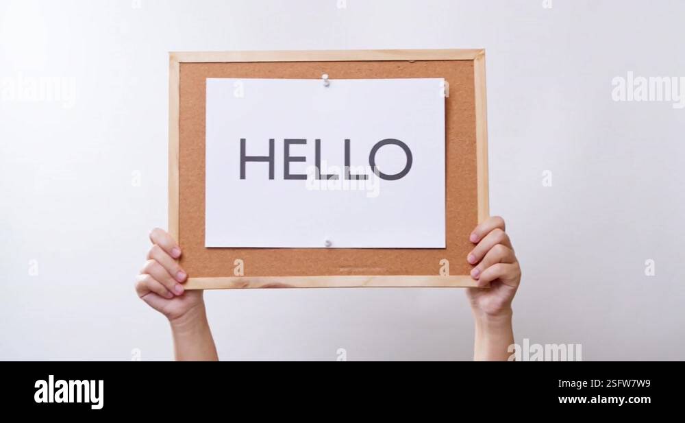 Woman's hand shows the paper on board with the word HELLO in white ...