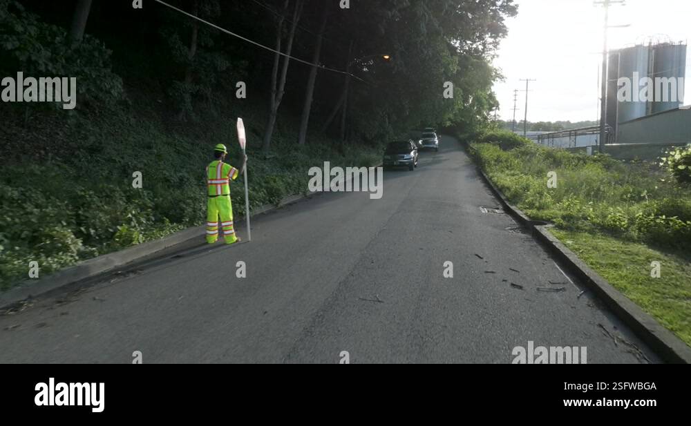 Road Construction Flagger Directing Traffic Along Road Holding Slow ...