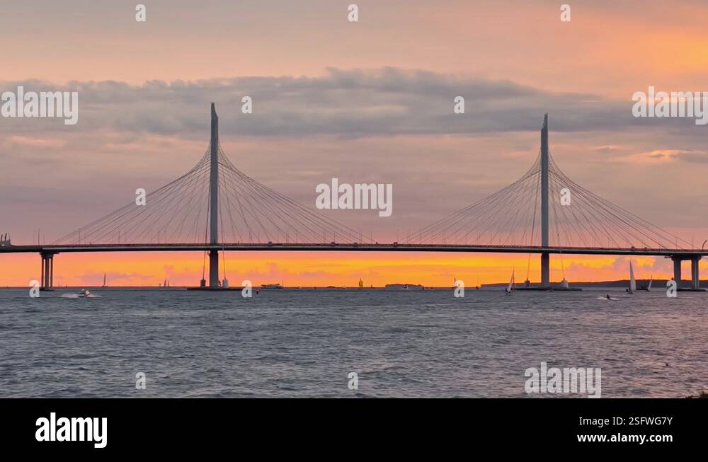footage of cable-stayed bridge at sunset, car traffic on the highway ...