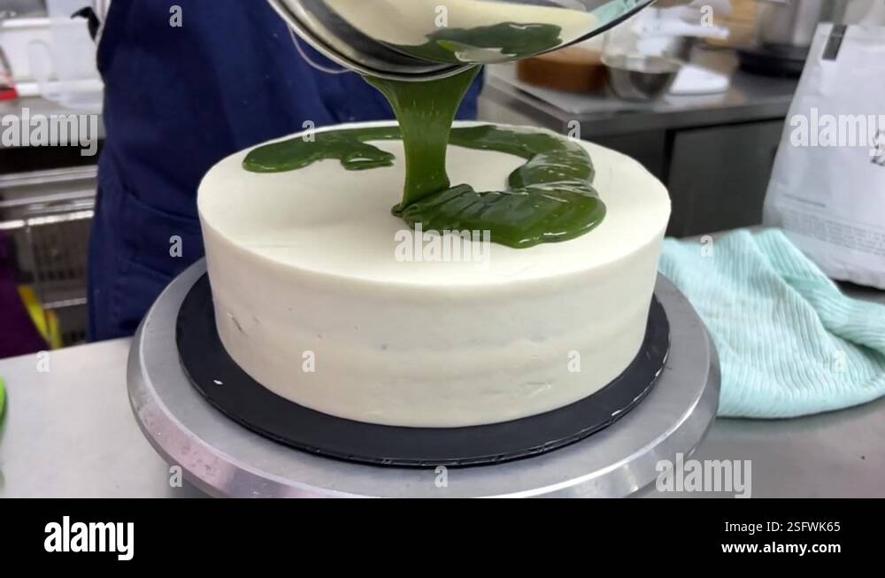 Patissier making a drip cake with matcha green tea mirror glaze ...