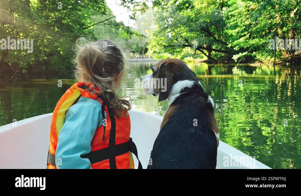 Girl child and her pet beagle dog are floating down a river on a boat ...
