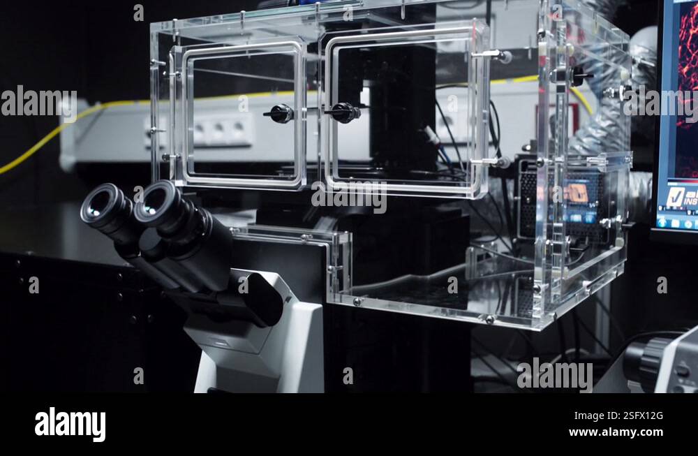 Pan down to a modern microscope model with a plexiglass box to hold the ...