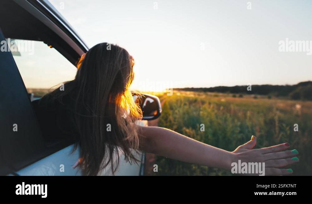 Happy family travel. Little girl leaning out of car window waving hand ...
