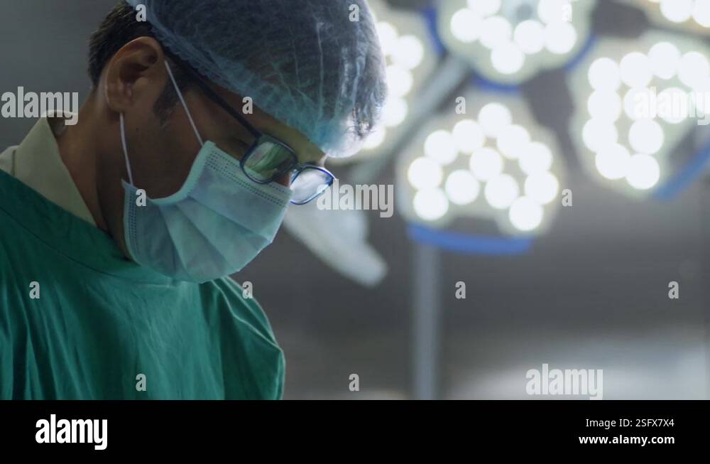Indian male surgeon doctor is busy operating a surgery with a nurse in ...