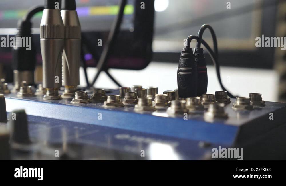 Male hand of sound engineer unplugging the audio cable of a mixer panel ...