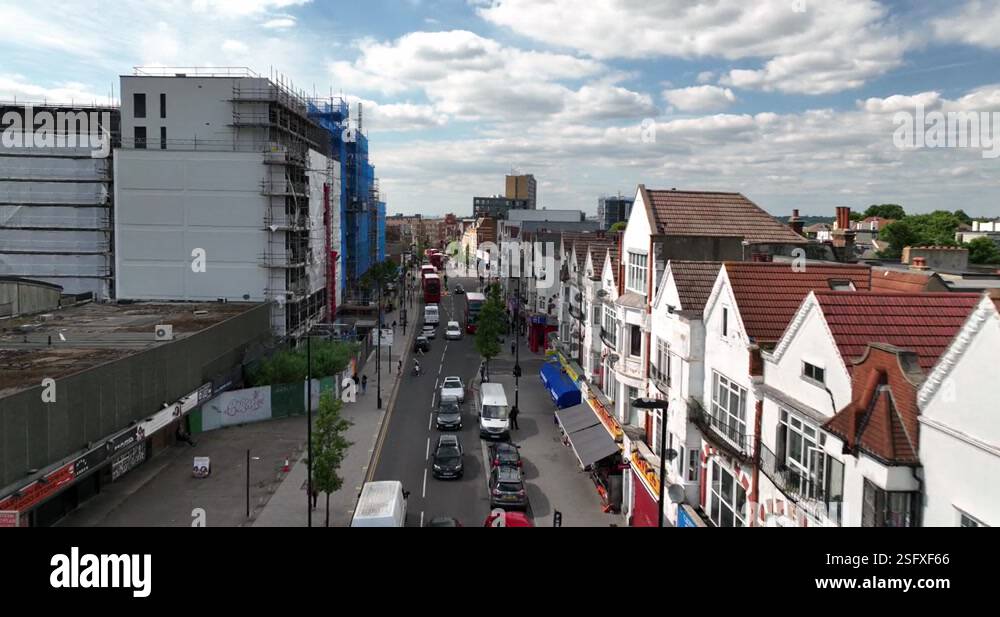 Traffic in narrow street in urban borough, row of houses and ...