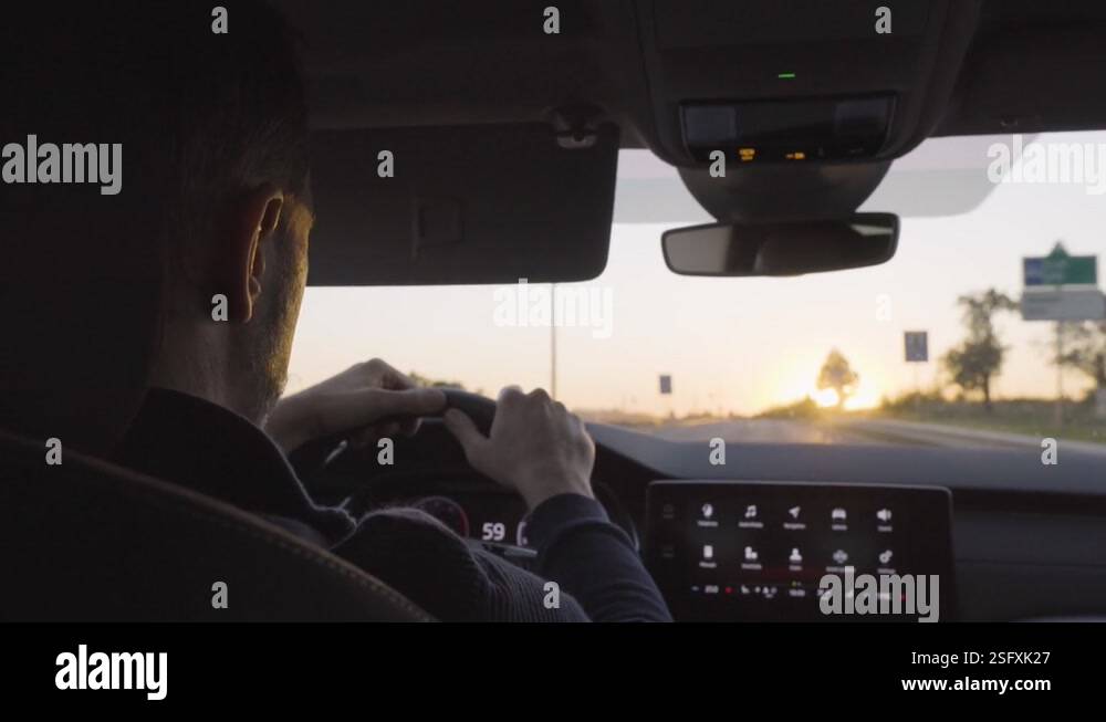 A middle-aged handsome Caucasian man pulls down a sun visor as he ...