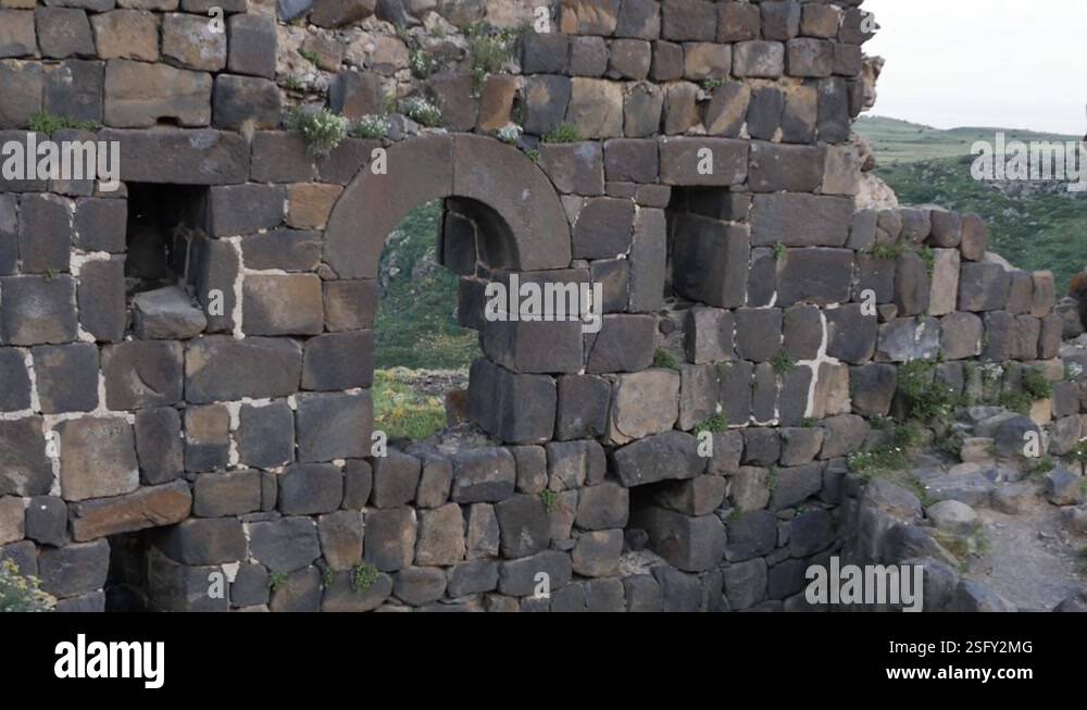A fragment of a stone wall of an ancient ruined castle with large and ...