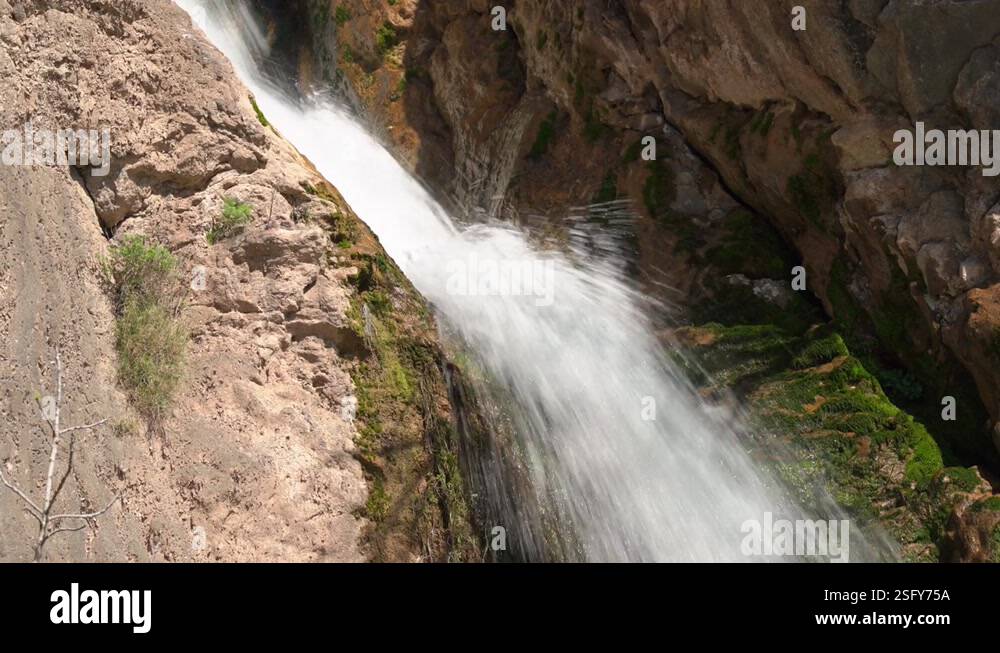 Small waterfall with roaring stream of flowing water between rocks ...