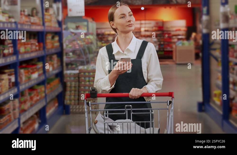 Customer goes with shopping cart checking shopping list Stock Video ...