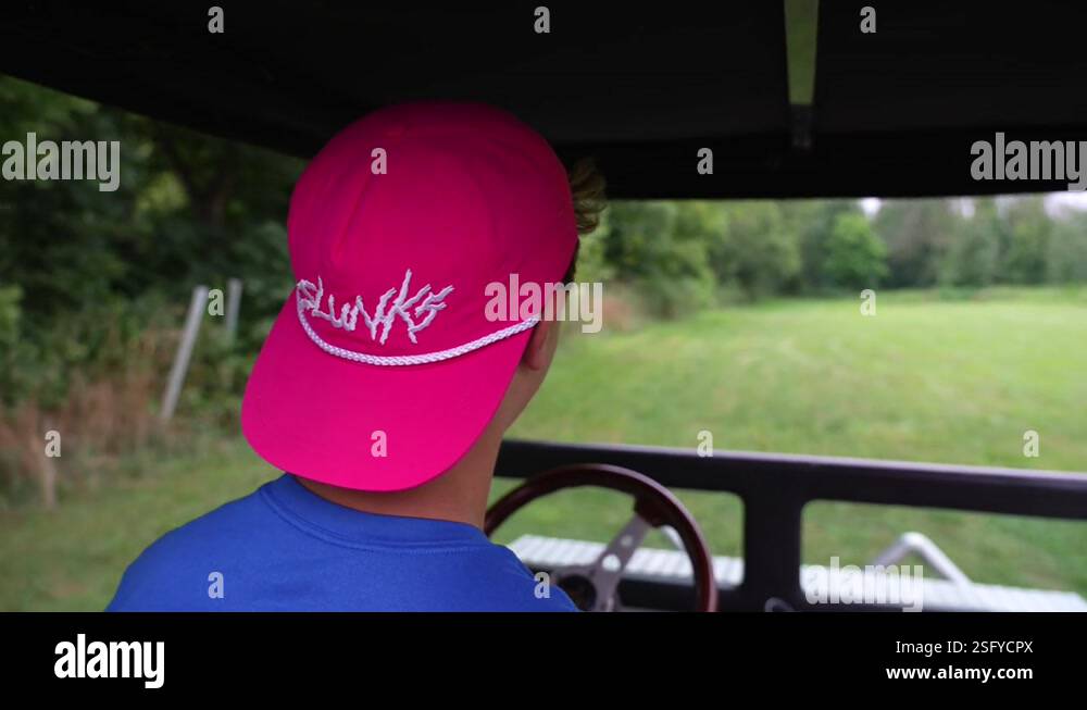 Teenage boy drives golf cart, off-road vehicle, while wearing pink ...