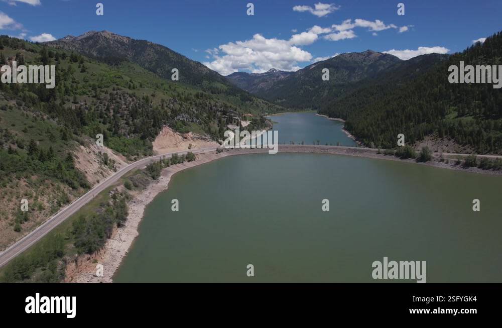 Drone flies near a dam with a road on it. The dam separates two bodies ...