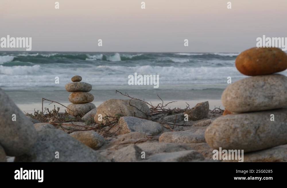 Rock balancing on pebble beach. Pyramid stacks of stones, ocean coast ...