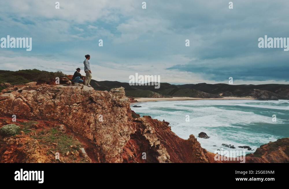 Two men on top of the coastal cliffs shot by drone Stock Video Footage ...