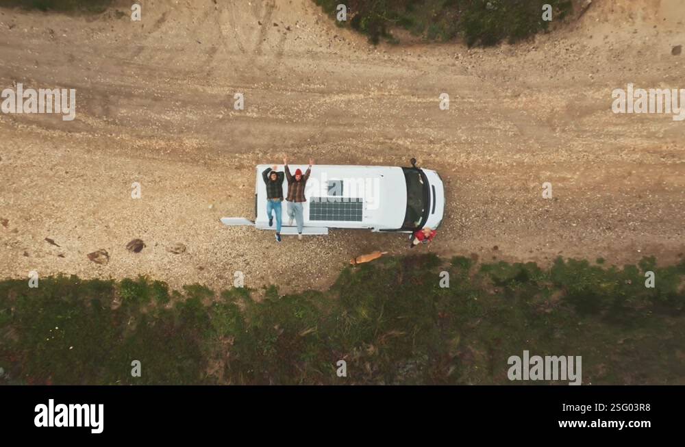 Two men lays on top of van drone shot zooming out Stock Video Footage ...