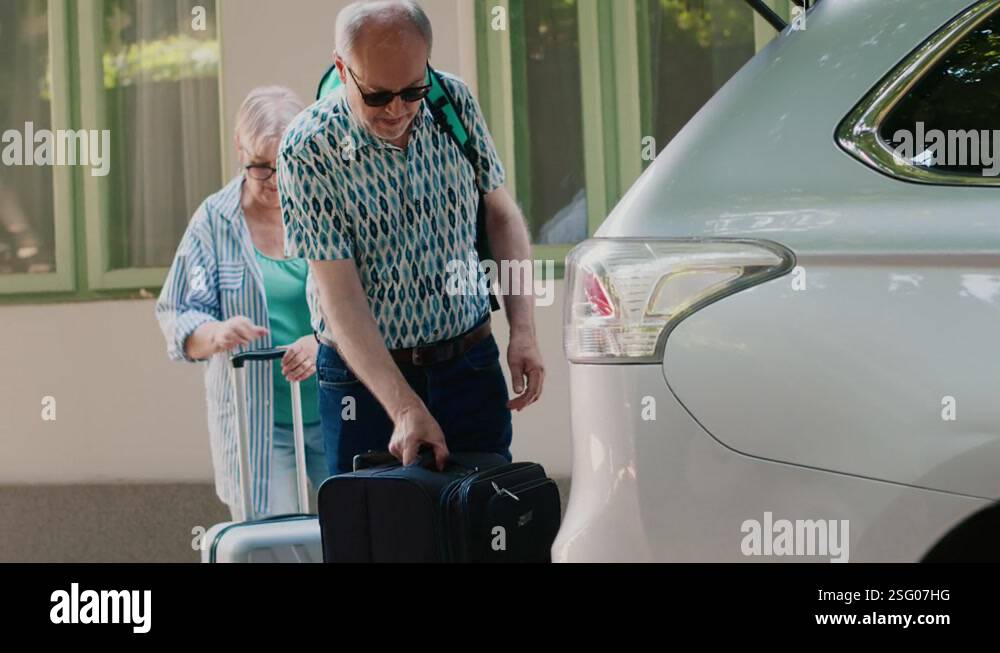 Elder people loading vehicle with baggage and trolleys Stock Video ...