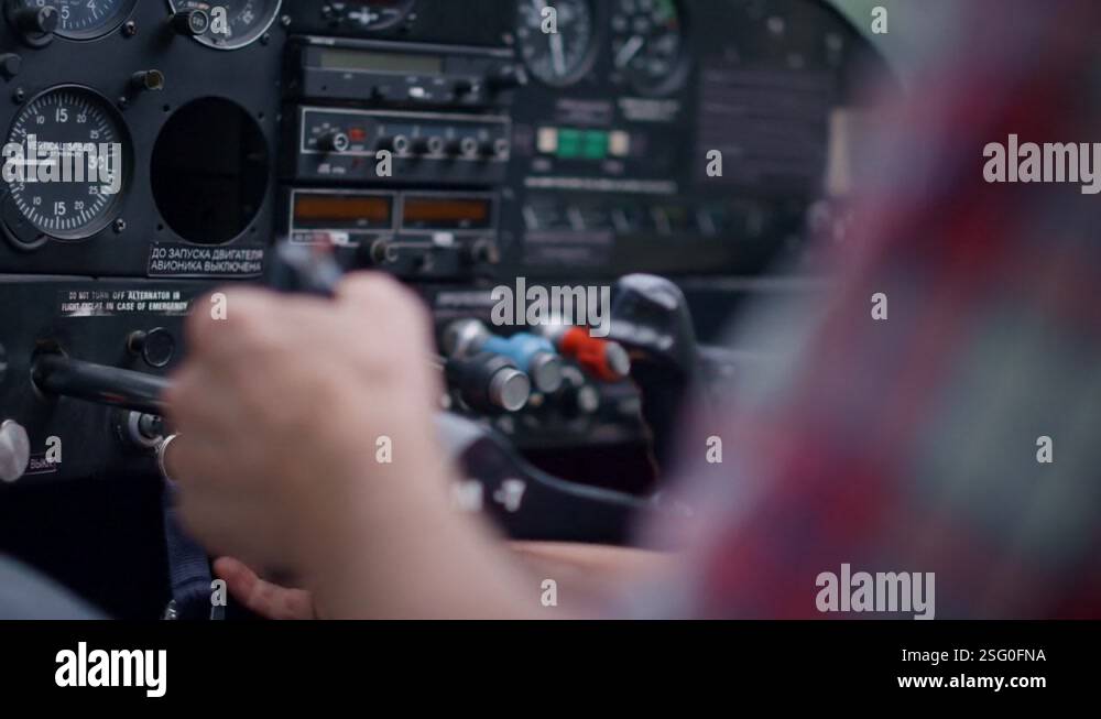 Pilot starting airplane engine using key sitting in modern plane cabin ...