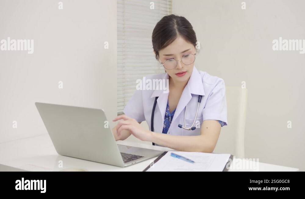 Asian female doctor using laptop answer questions from patients at home ...