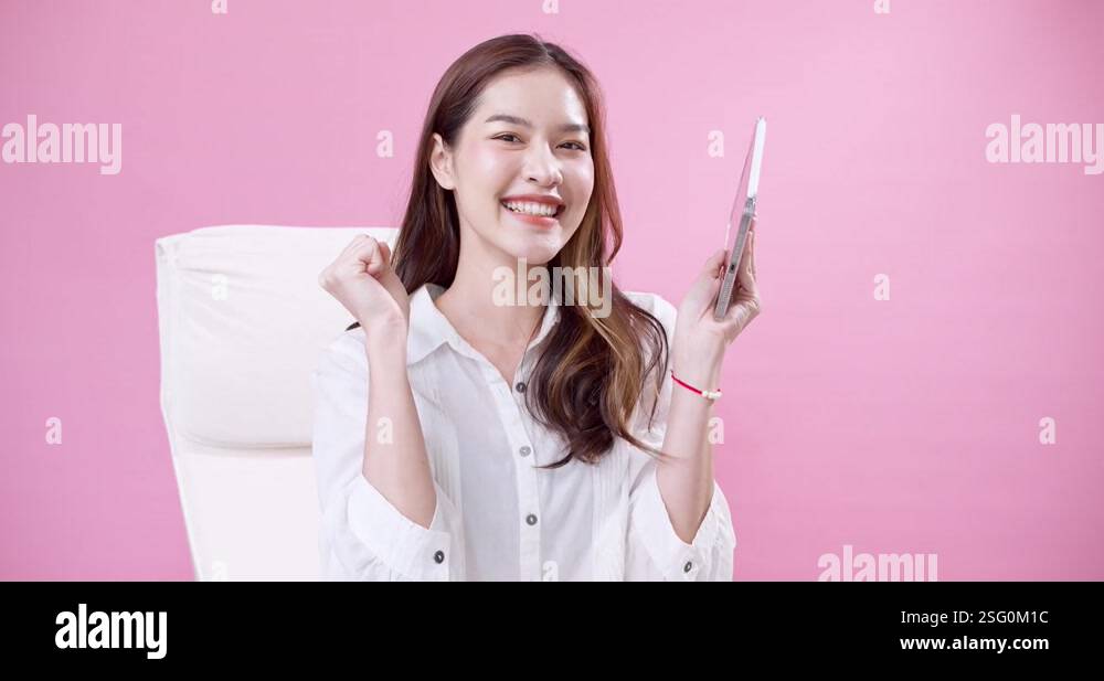 Asian girl shaking hands and posing while sitting on a chair in front ...