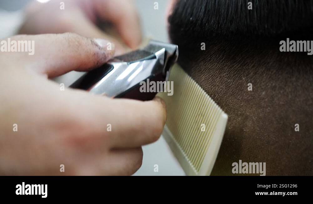 Barber shaves the back of the client's head with a trimmer. A close-up of a comb Stock Video ...