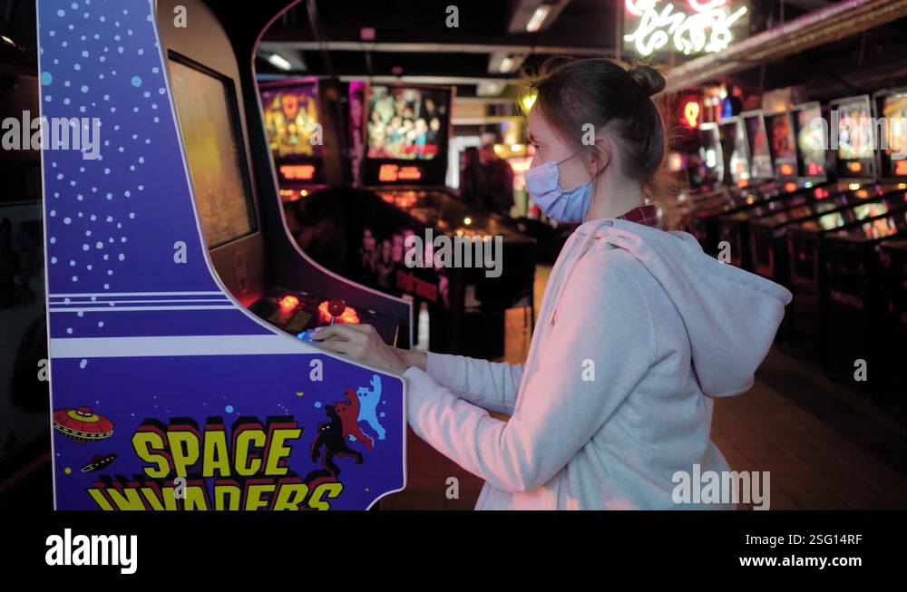 Woman pushing buttons and playing fighting game arcade machine Stock ...