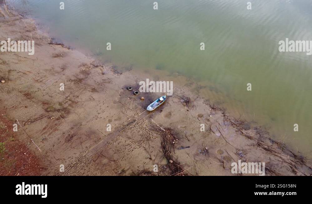 Old wooden boat on the bank of the river among the twigs waste with a ...