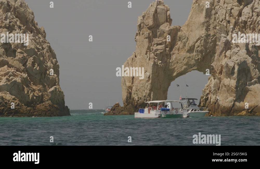 Slow motion of boats in front of rock arch in Cabo San Lucas, Mexico ...