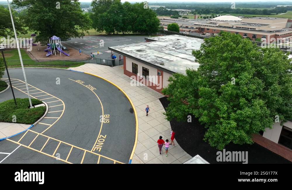 Students on sidewalk at school. Recess and outdoor playground. Bus zone ...