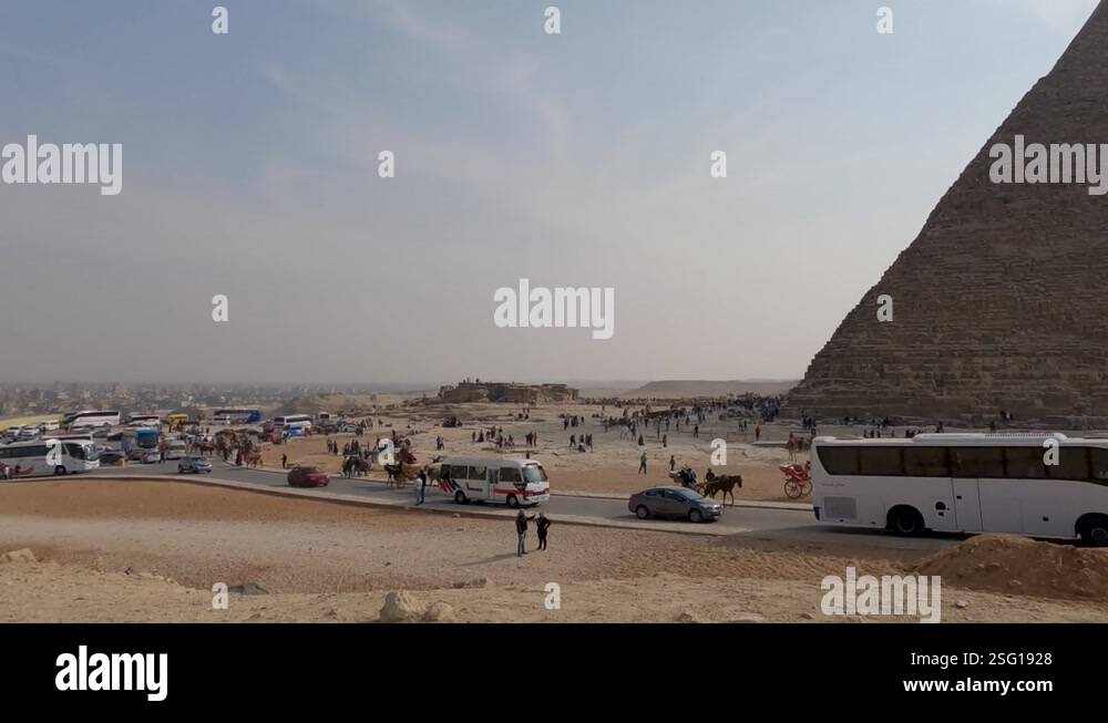 Tourists arriving in buses, cars and horse carts at the pyramid complex ...