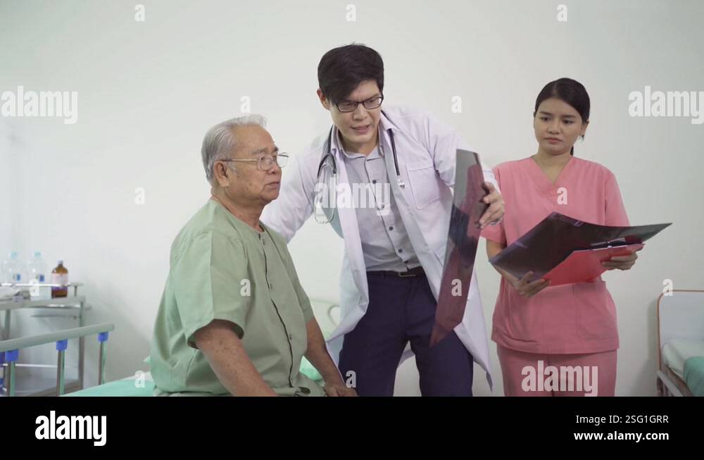Portrait of Asian doctor showing bone x-ray scan film of sick old ...