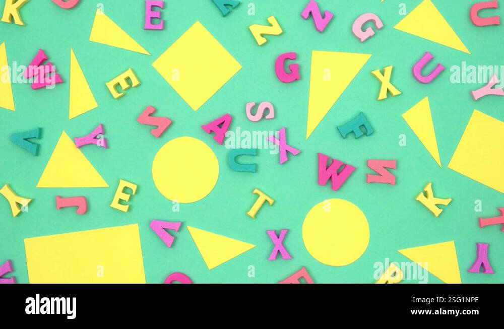 geometric shapes and letters randomly lie on a rotating green ...